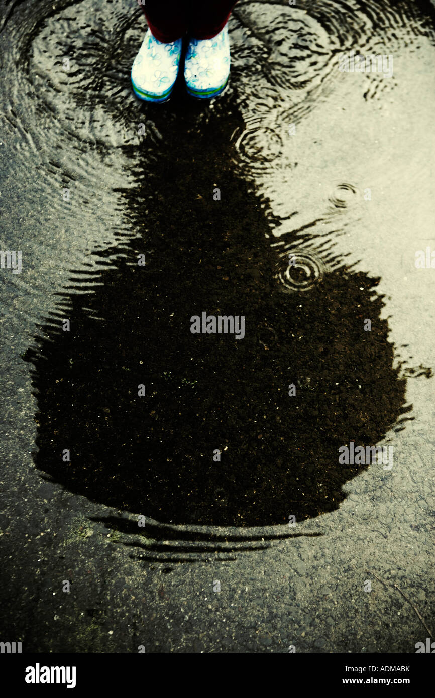 Reflection in a puddle, child with wellington boots Stock Photo - Alamy