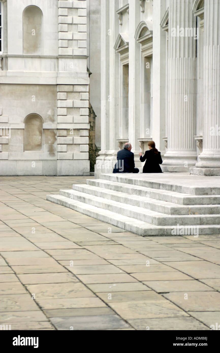 Two people sitting outside Senate House Cambridge Stock Photo - Alamy