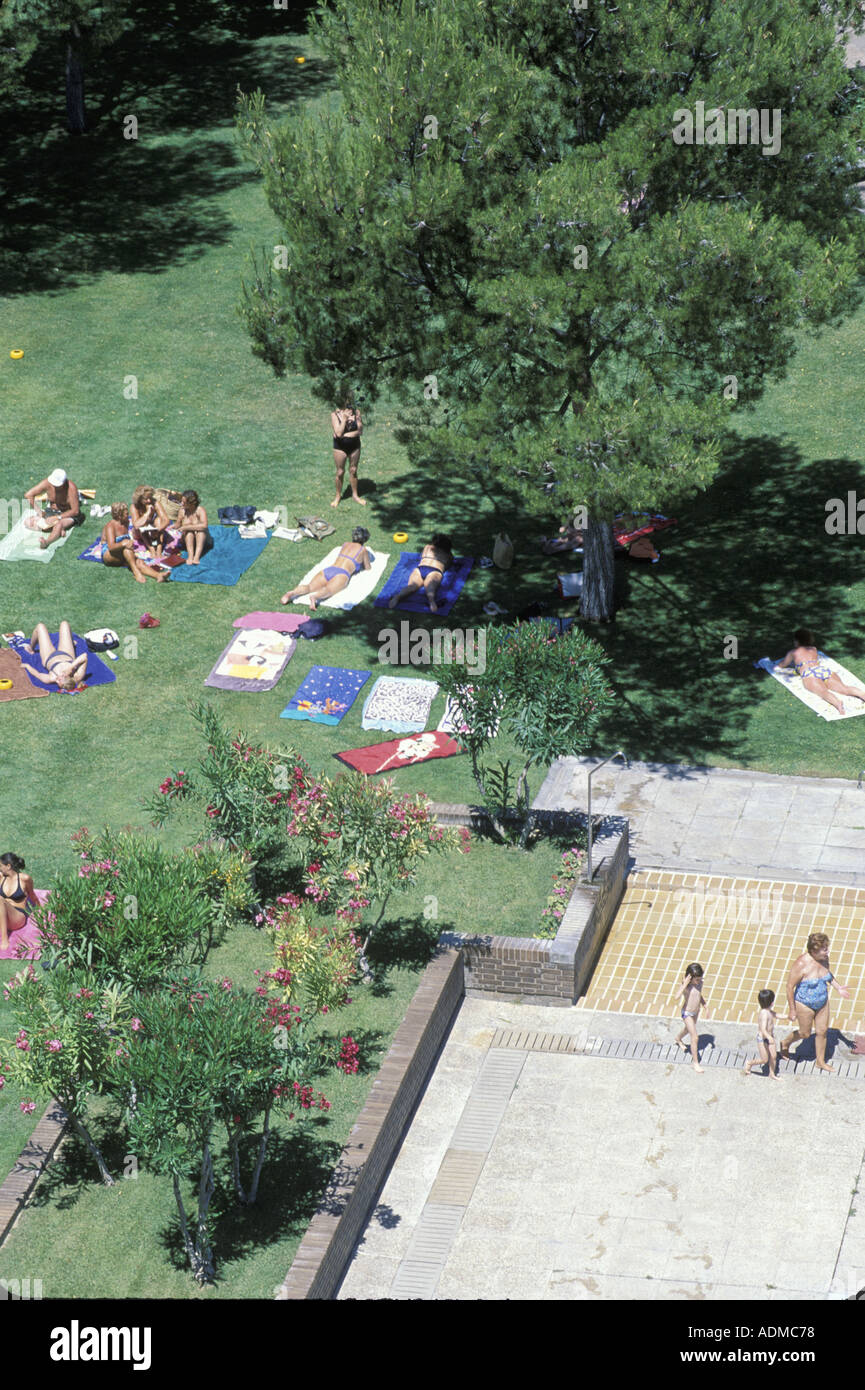 People sunbathing and swimming in a swimming pool in Spain summer time ...