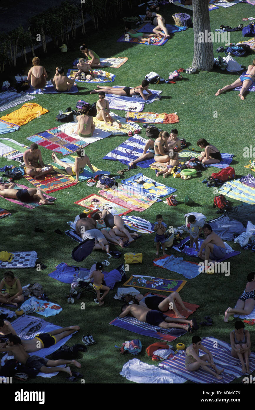 People sunbathing and swimming in a swimming pool in Spain summer time ...