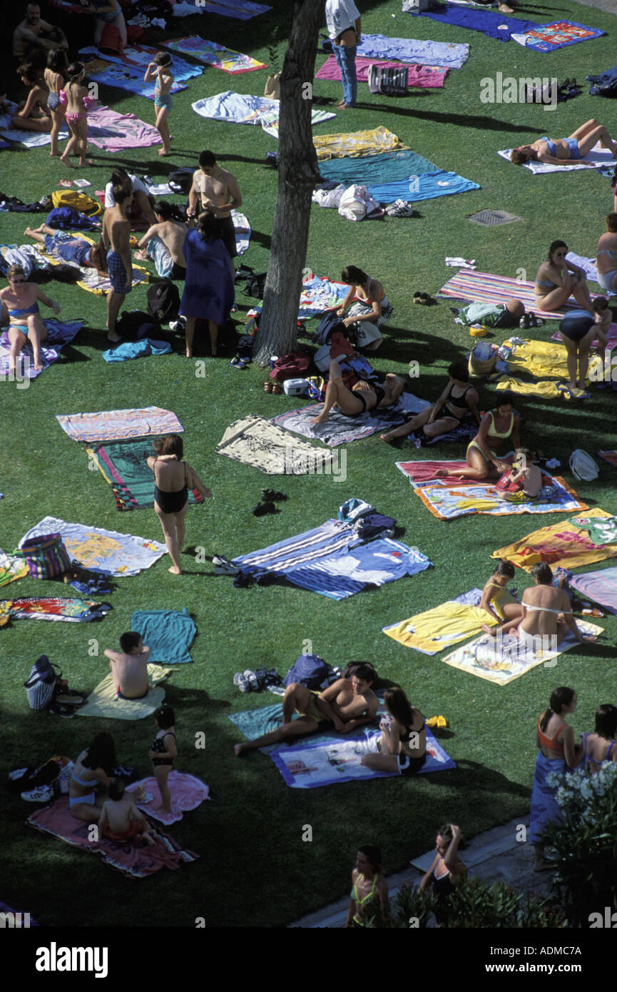 People sunbathing and swimming in a swimming pool in Spain summer time ...