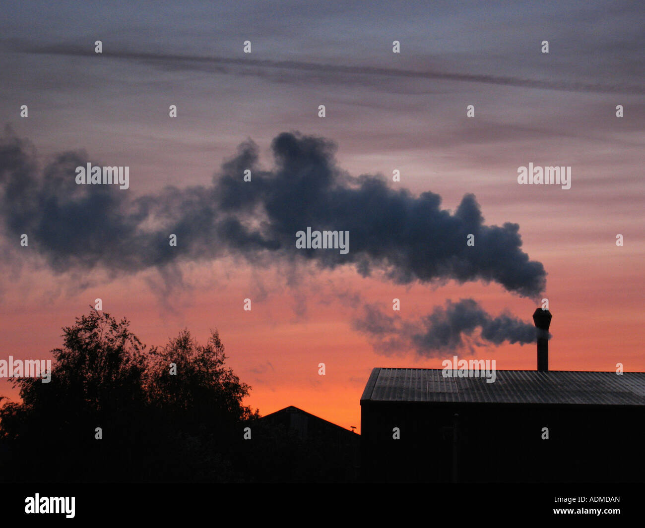 Factory chimney releasing steam at dusk Stock Photo - Alamy