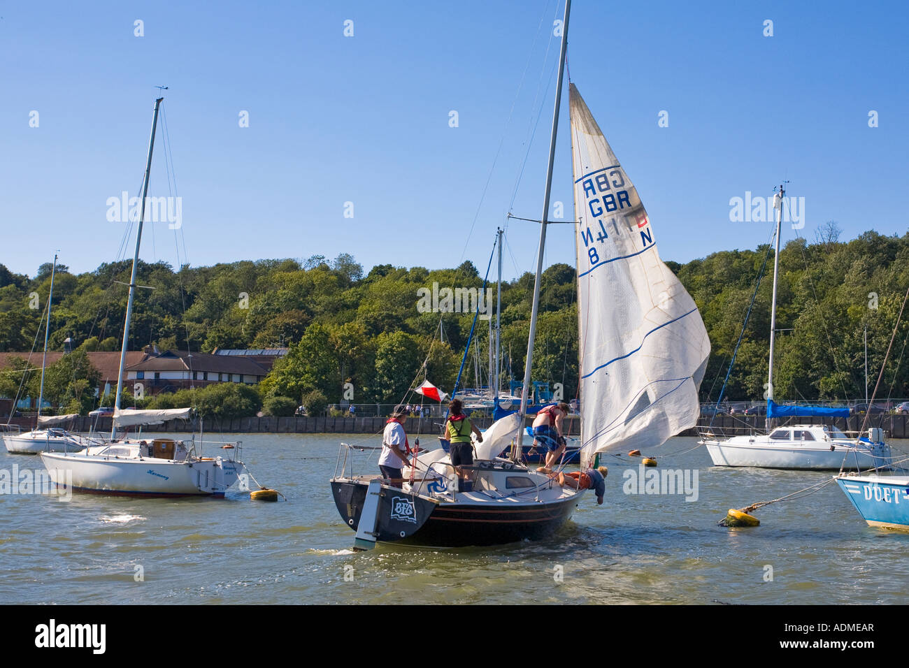 A small racing sailing boat attempting to sail onto its mooring on the ...