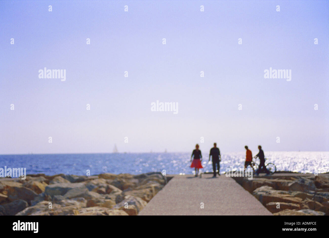 people walking on rocks by beach Stock Photo - Alamy