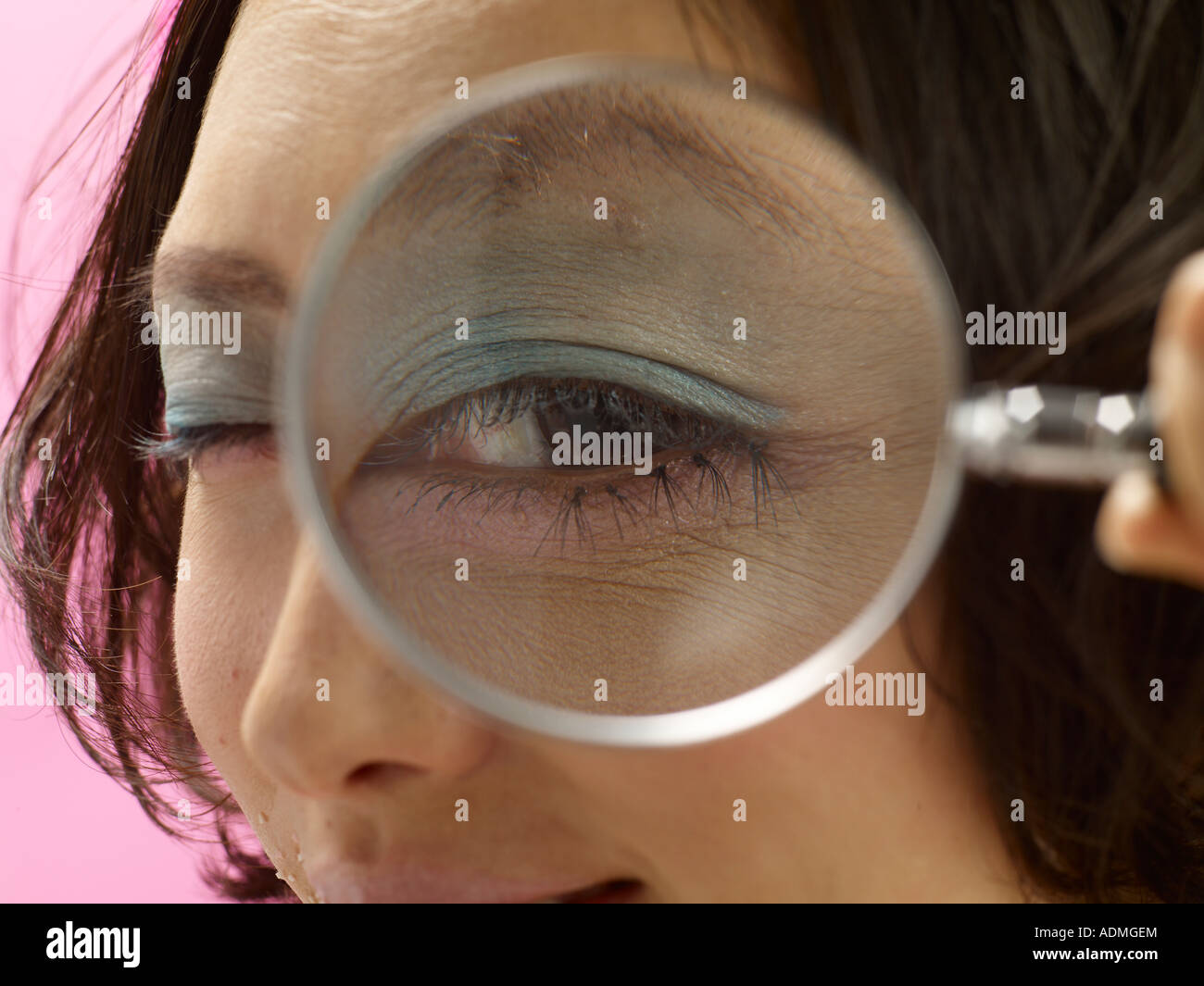 Woman looking through a magnifying glass close up Stock Photo - Alamy