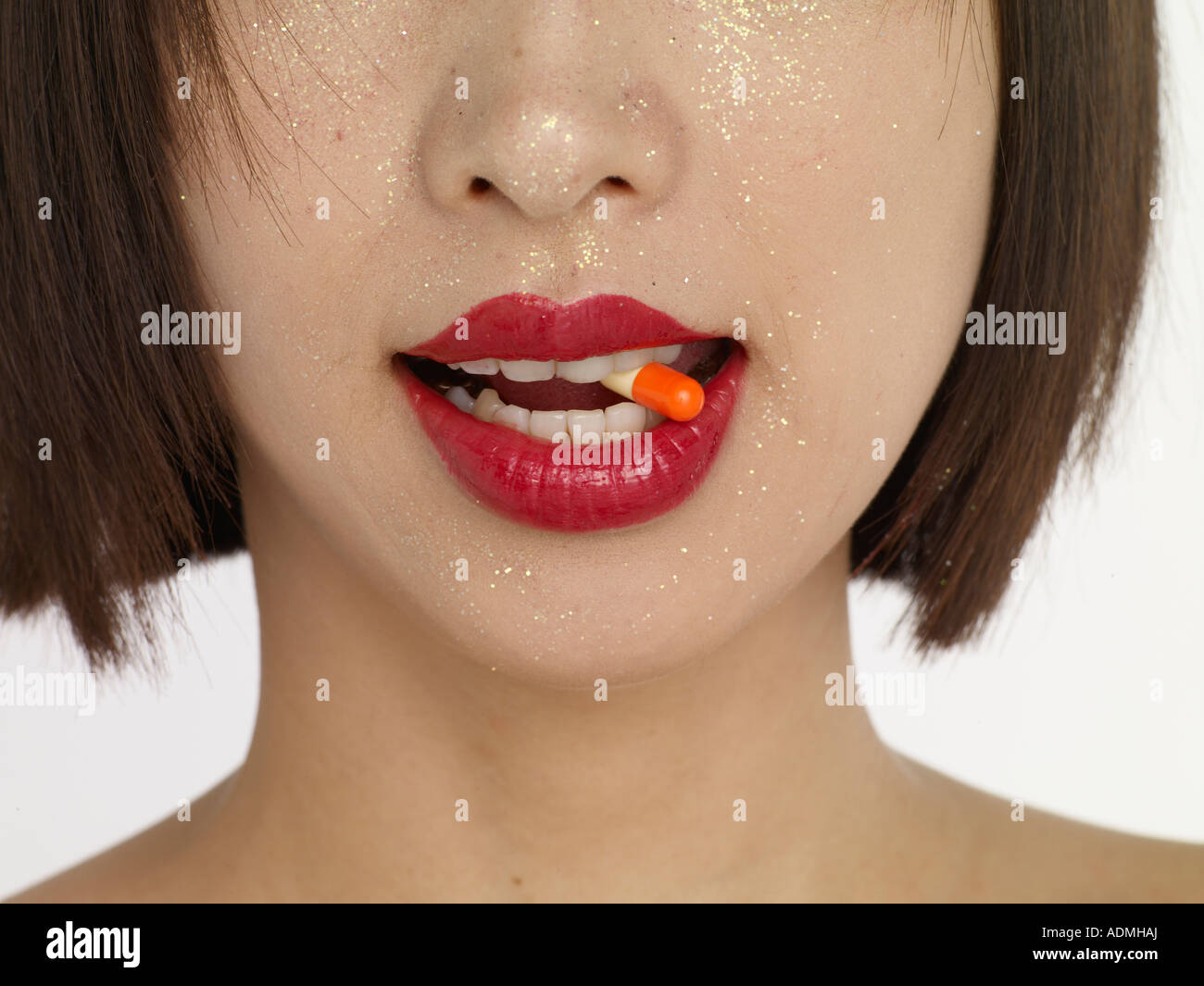 Close up of a woman with red lips biting a pill Stock Photo - Alamy