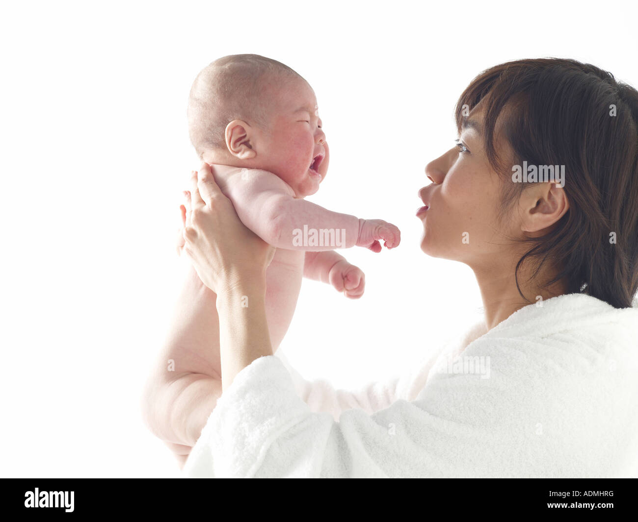 Mother holding up her crying baby Stock Photo - Alamy