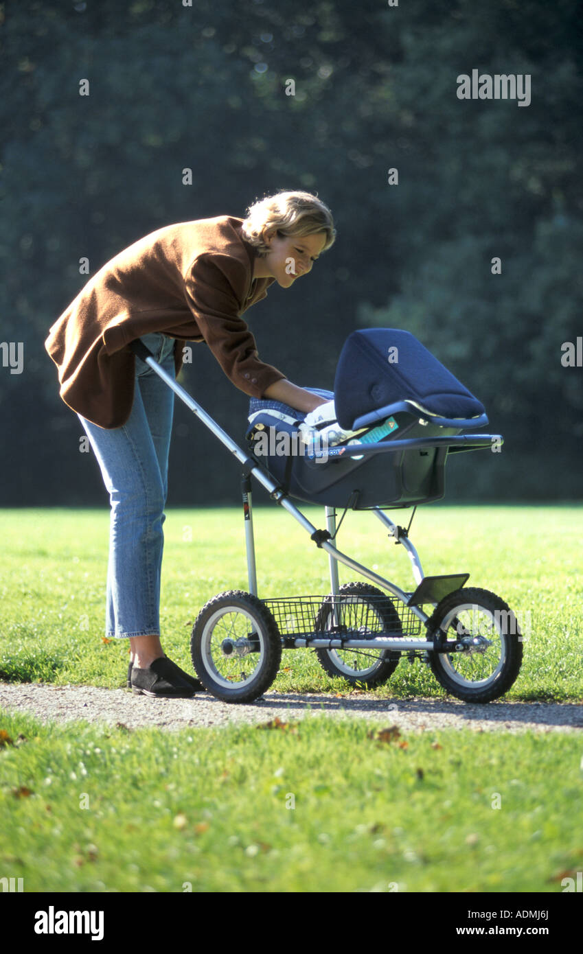 Mother taking her baby for a walk in the buggy in the parc Stock Photo ...