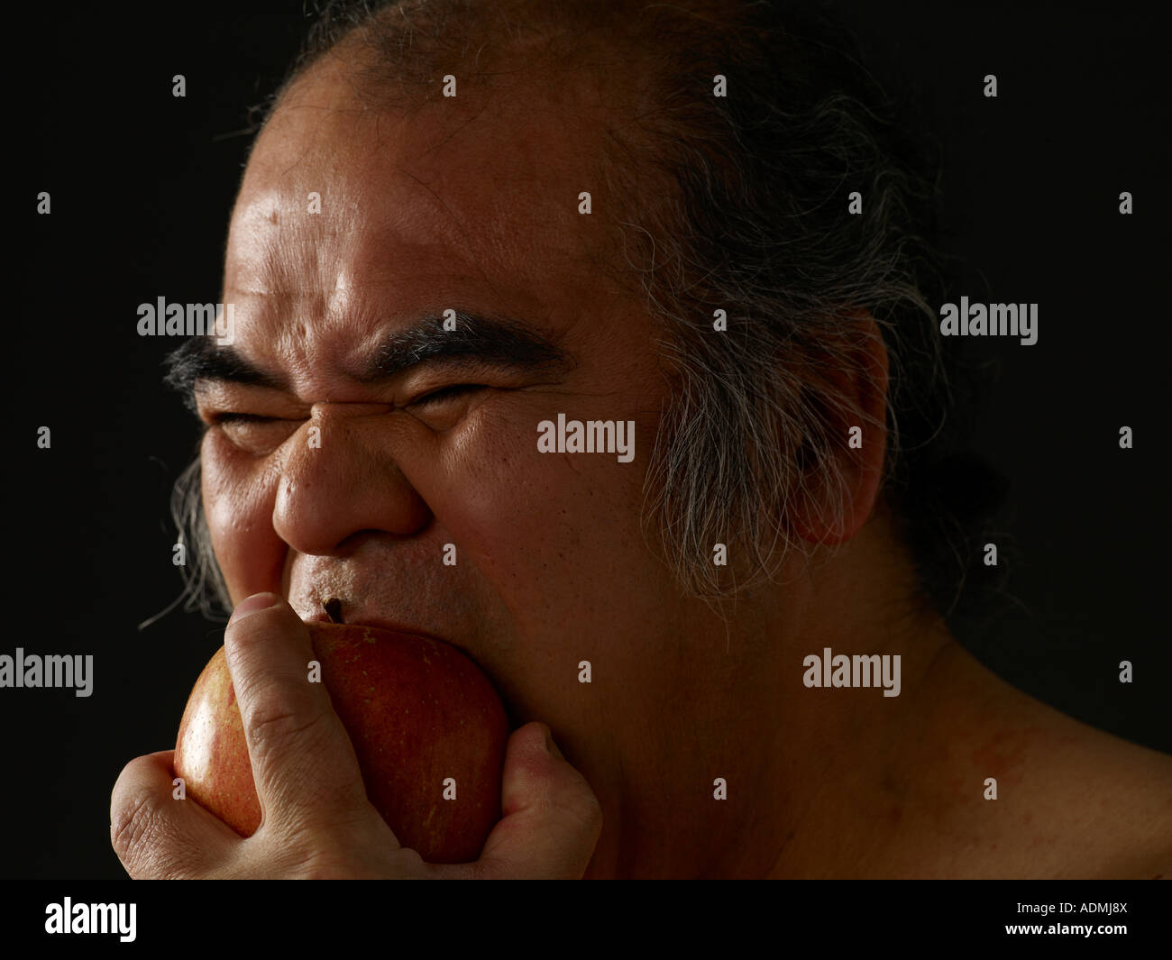 Mature man biting into an apple Stock Photo - Alamy