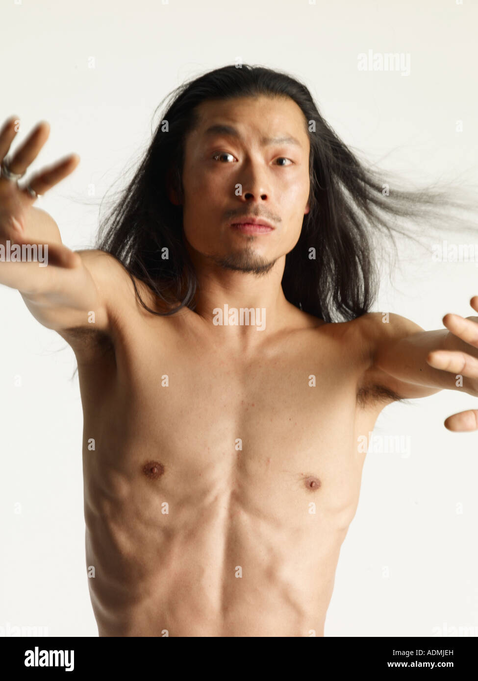 Shirtless young man with hands stretched out Stock Photo - Alamy