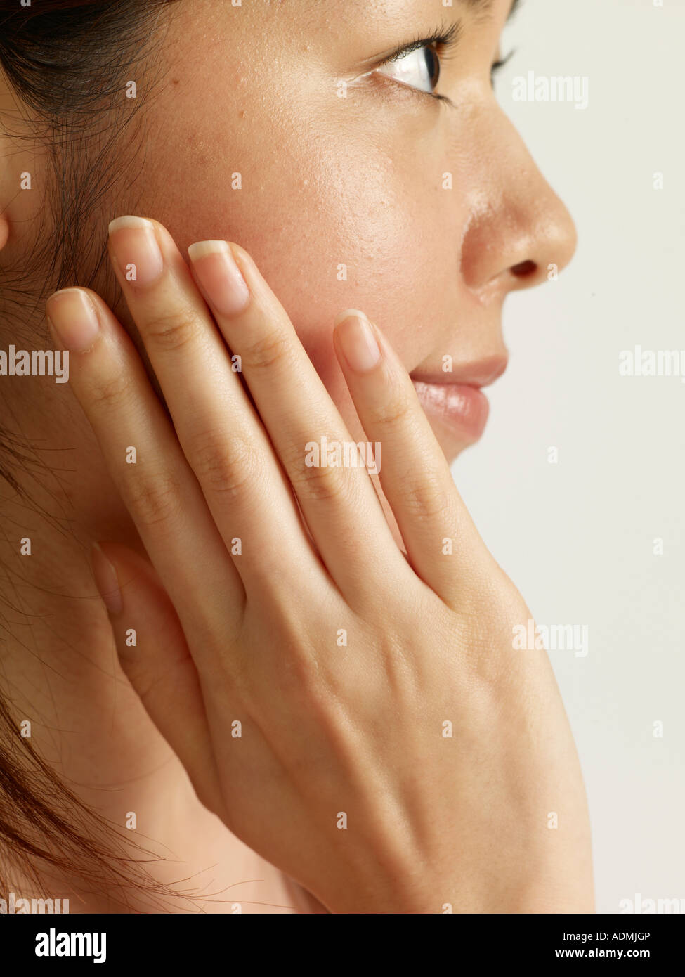 Woman touching her face side profile Stock Photo - Alamy