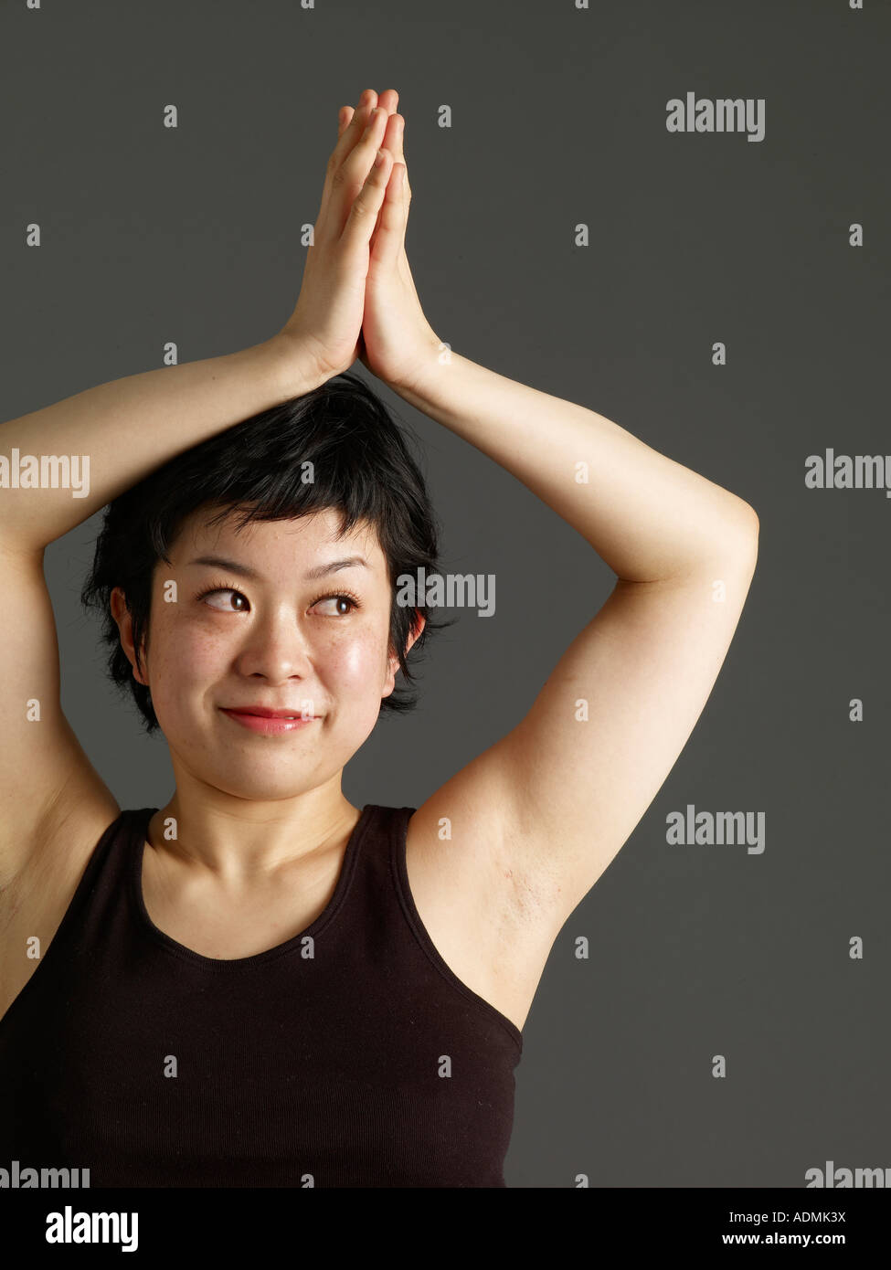 Woman with clasped hands above head Stock Photo - Alamy