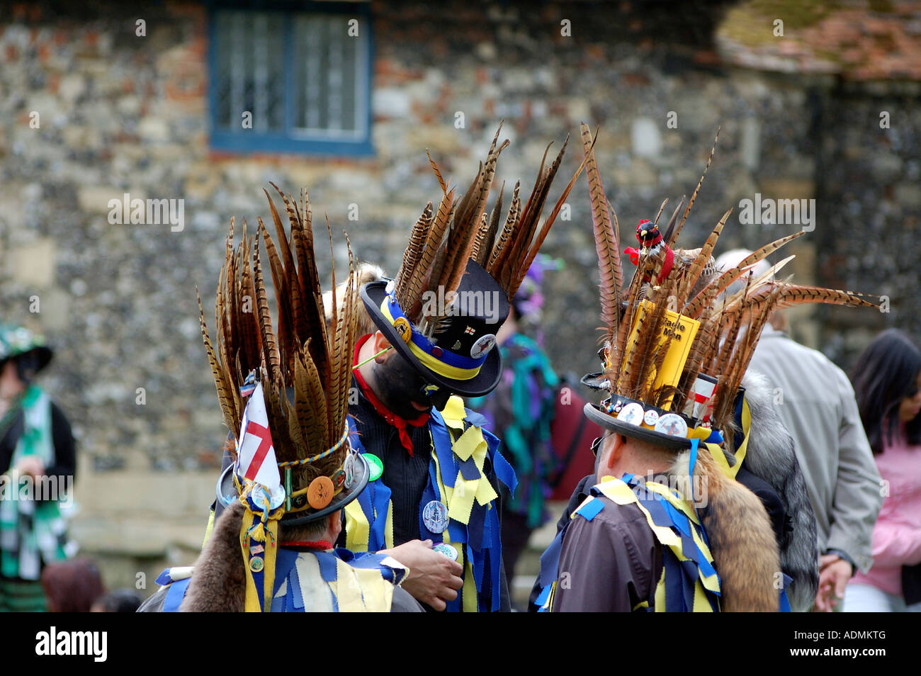A group of Morris dancers wearing hats of pheasant feathers chatting ...