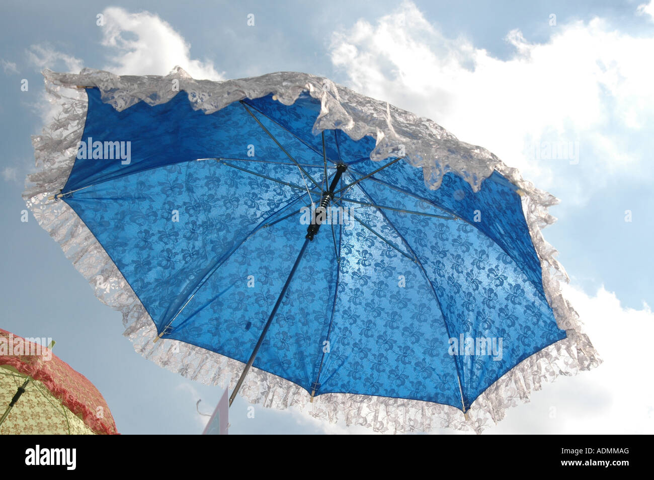 frog eye view of frilly blue parasol against blue skies Stock Photo - Alamy