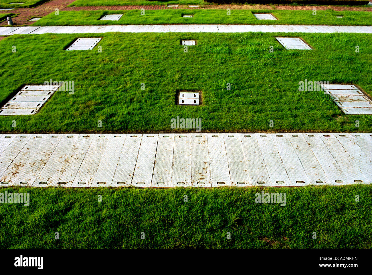 Covered manhole and grass Stock Photo - Alamy