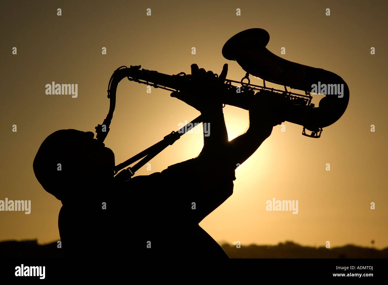 Saxophonist playing in the sunset Stock Photo - Alamy