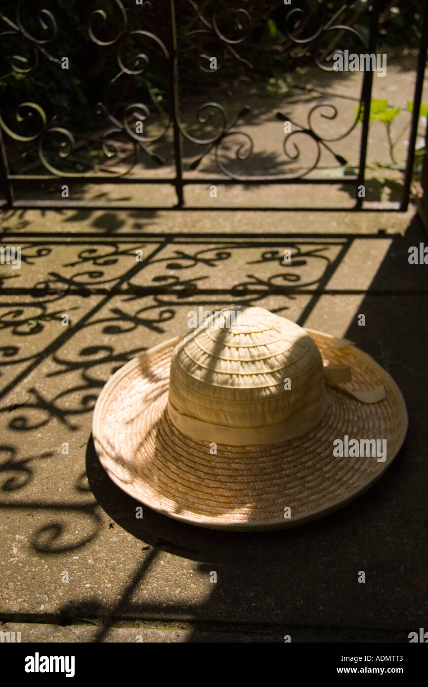 Straw hat in the shadow of a wrought iron gate Stock Photo - Alamy