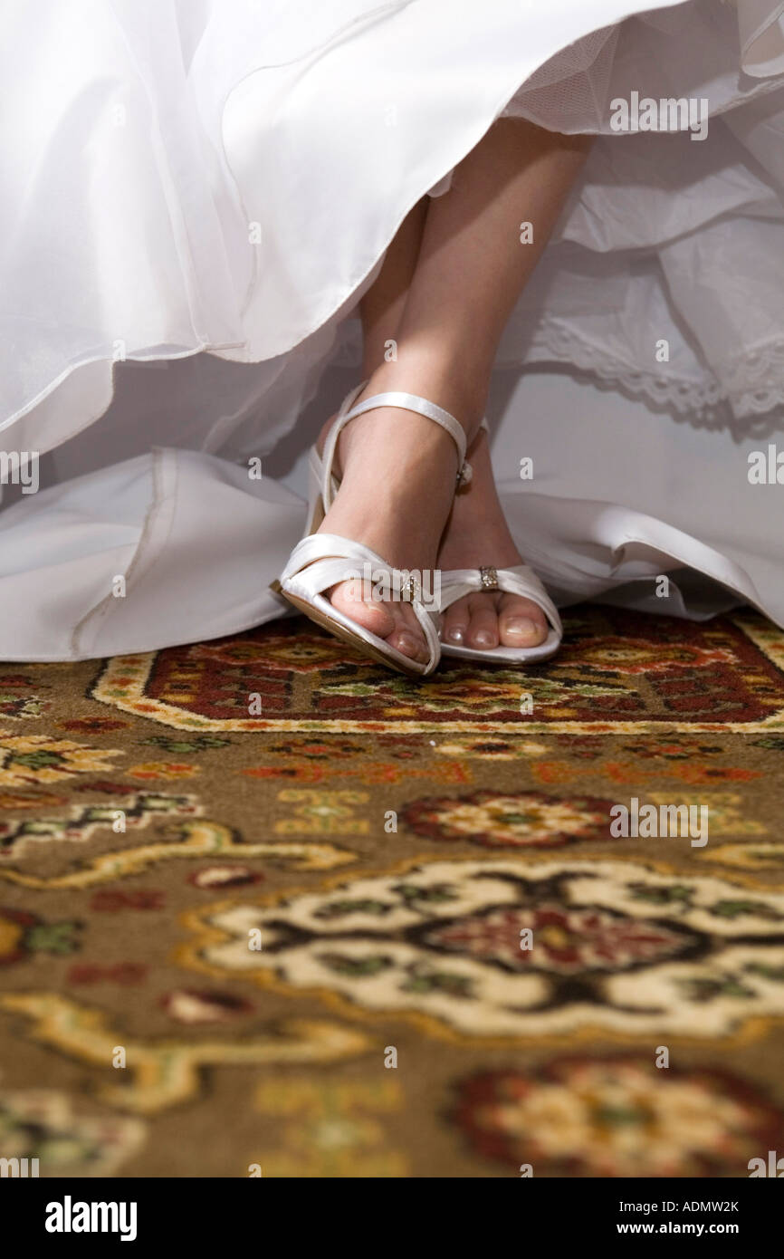 Detail shot of the bride's feet and her shoes underneath bridal dress ...
