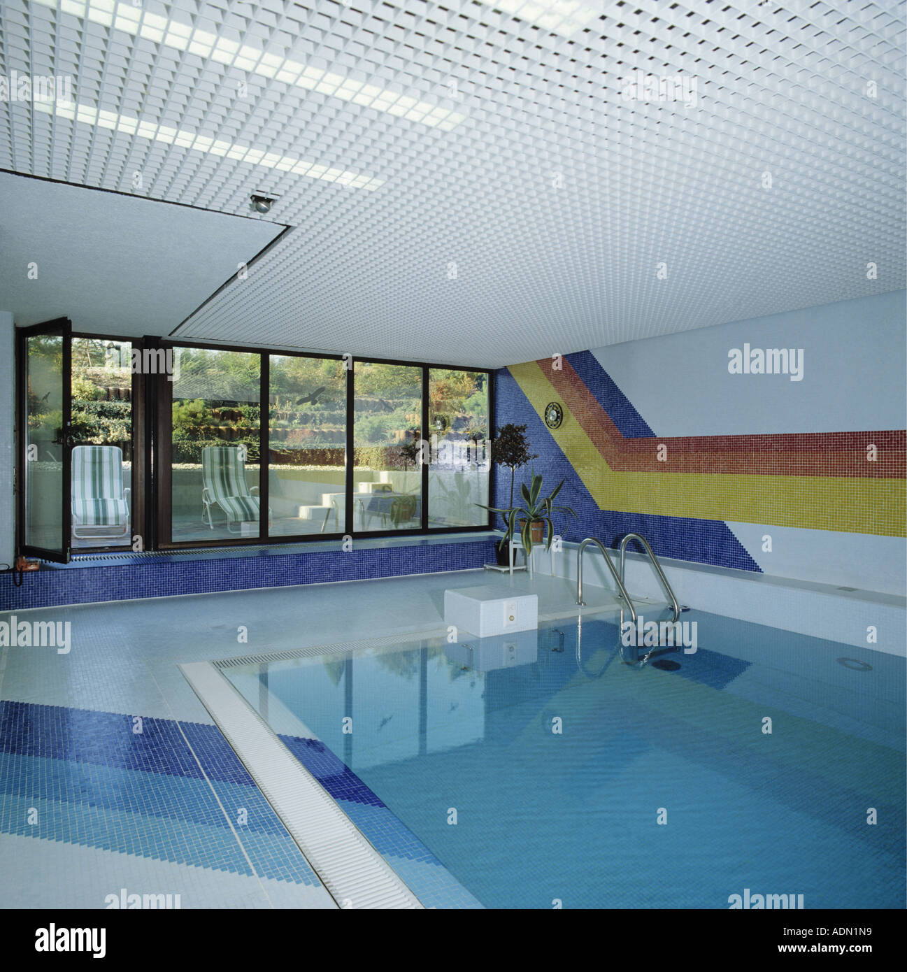 Colorful striped tiling on wall of modern indoor swimming pool with ...