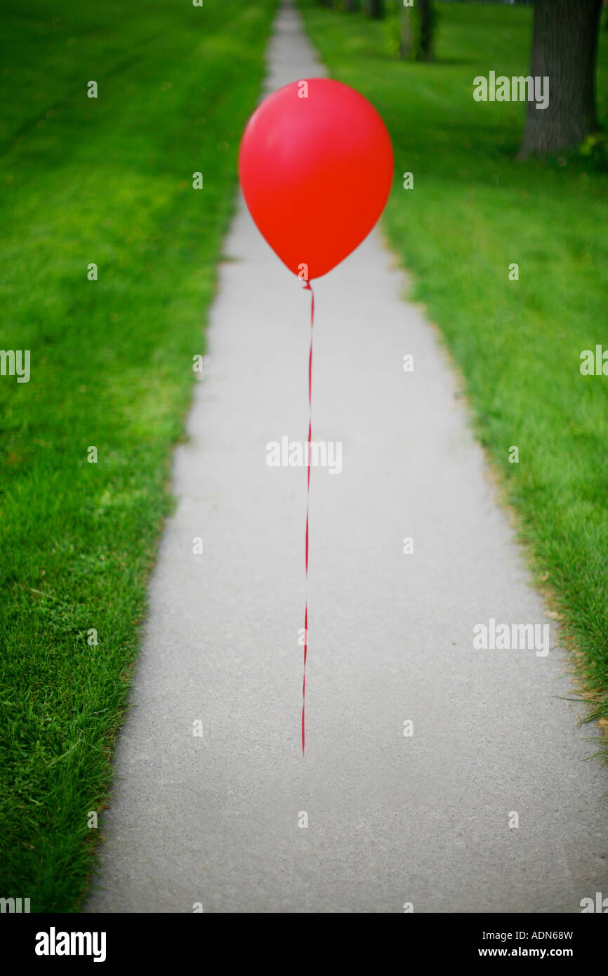 Single Red Balloon floating in the middle of a diminishing sidewalk ...