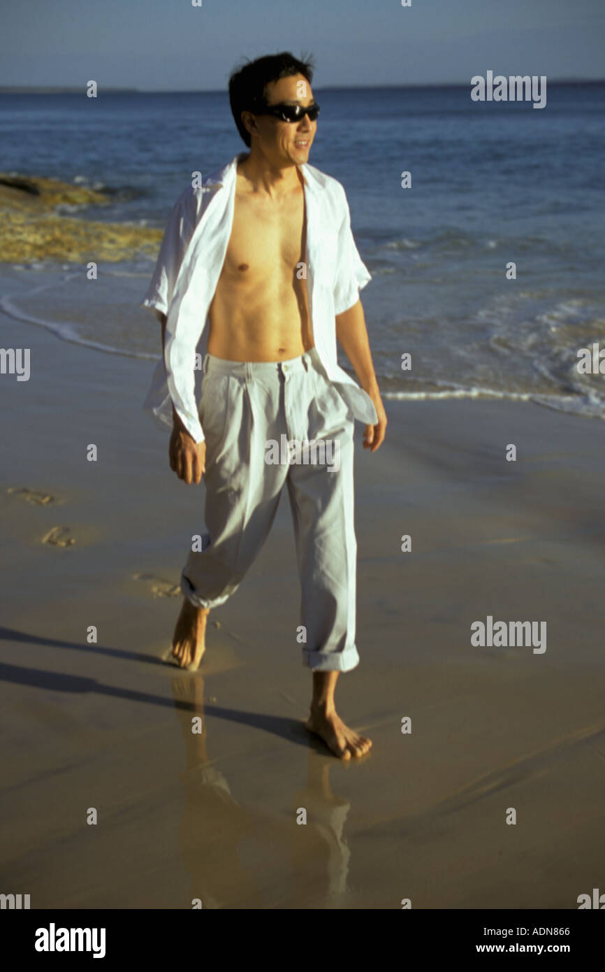 Australia Queensland man walking on beach Stock Photo - Alamy