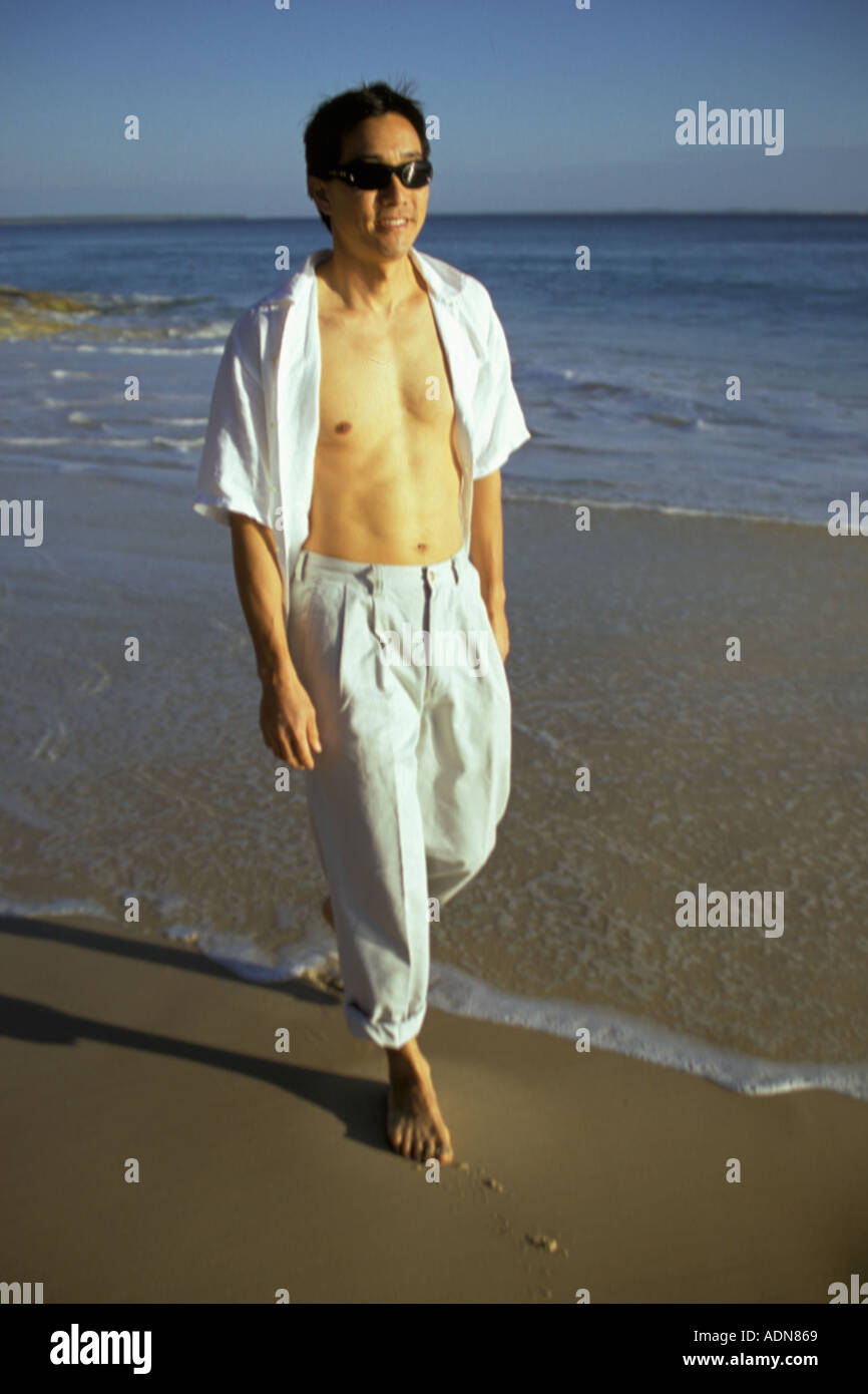 Australia Queensland man walking on beach Stock Photo - Alamy