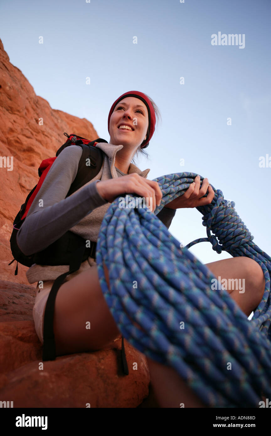 Girl rock climber coiling climbing rope Stock Photo - Alamy