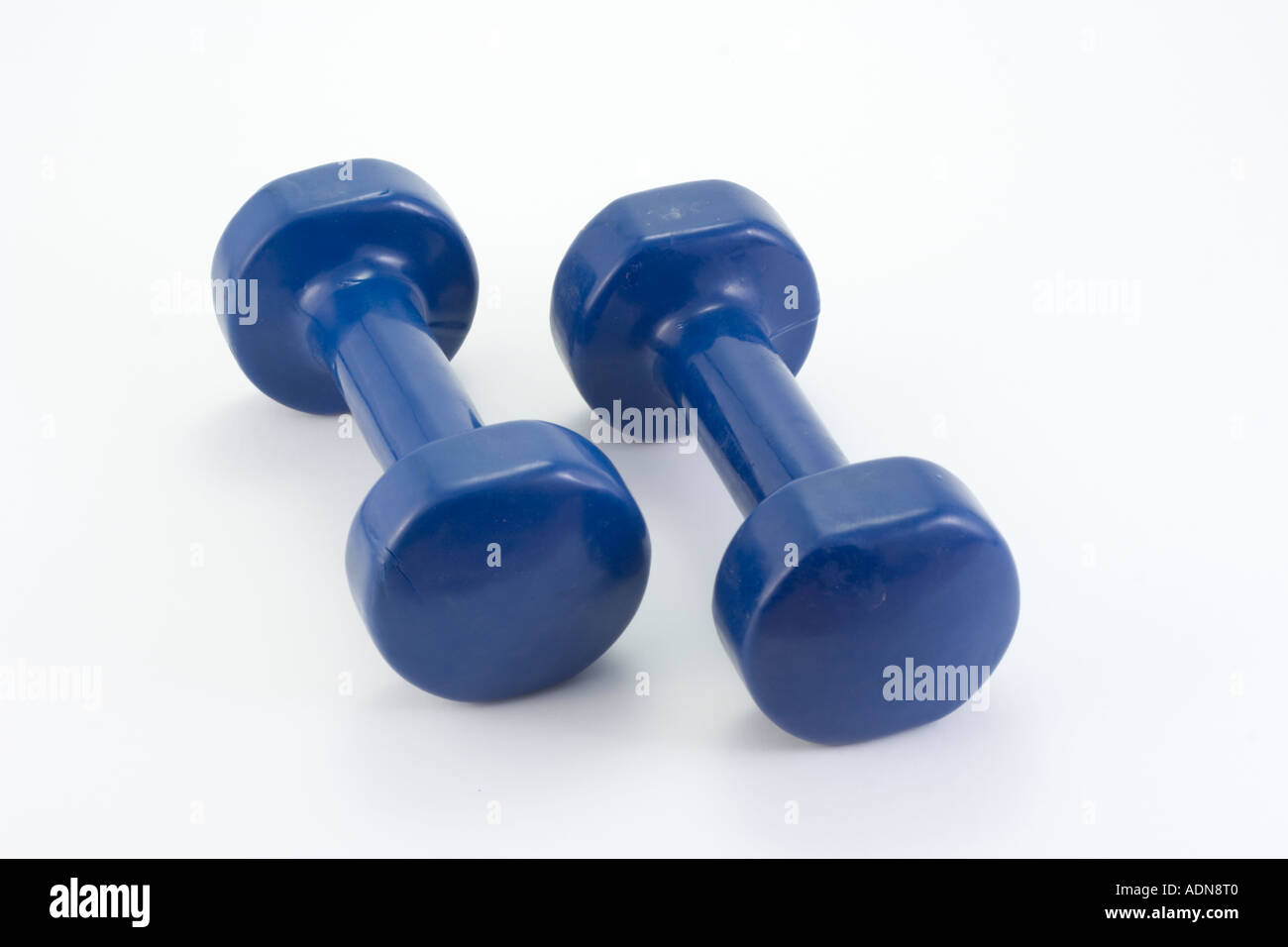 Pair of blue dumbbell training weights side by side on white background ...