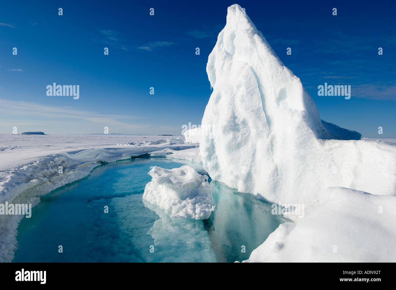 Meltwater pool at base of iceberg with crack in the ocean sea ice at ...