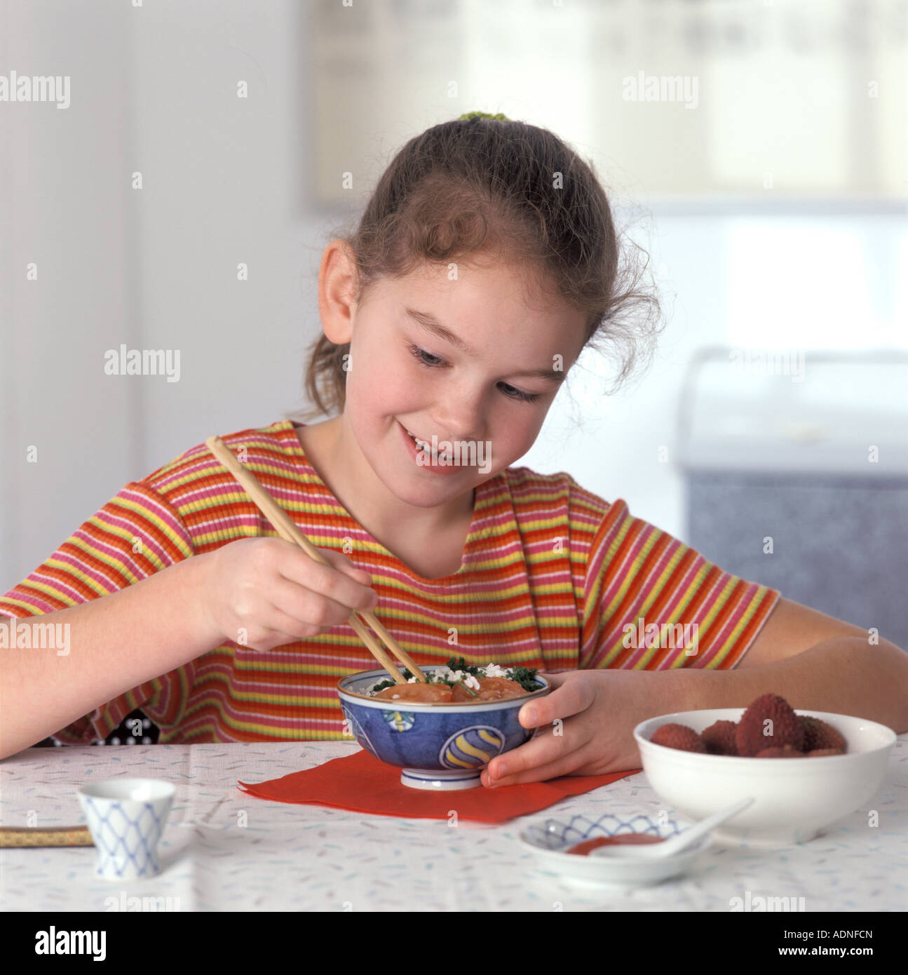 Girl eating rice with chop sticks Stock Photo - Alamy