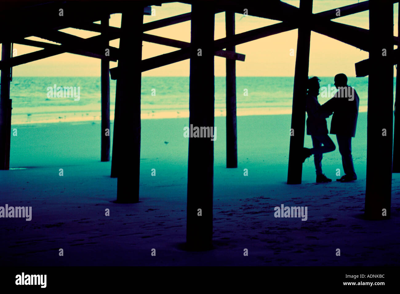 Silhouette of a young couple standing on the beach Stock Photo - Alamy