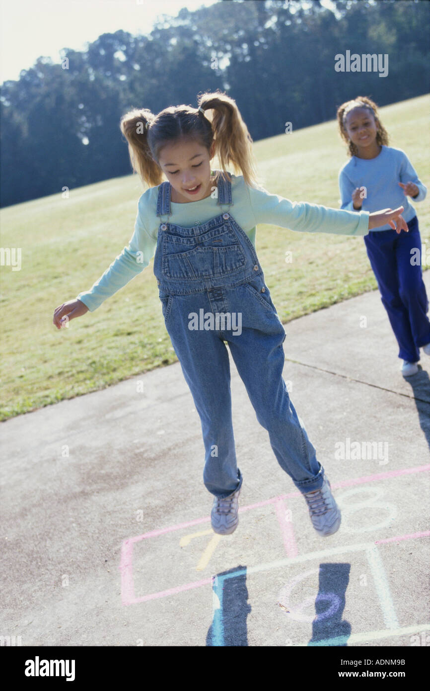 Two girls playing hopscotch Stock Photo - Alamy