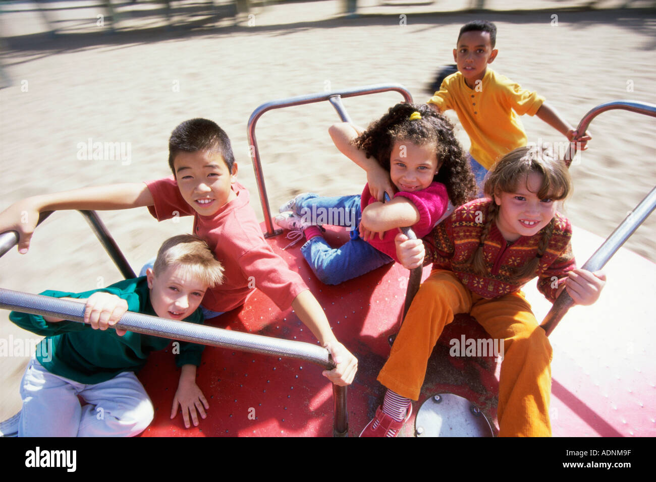 Portrait of a group of children sitting on a merry-go-round Stock Photo ...