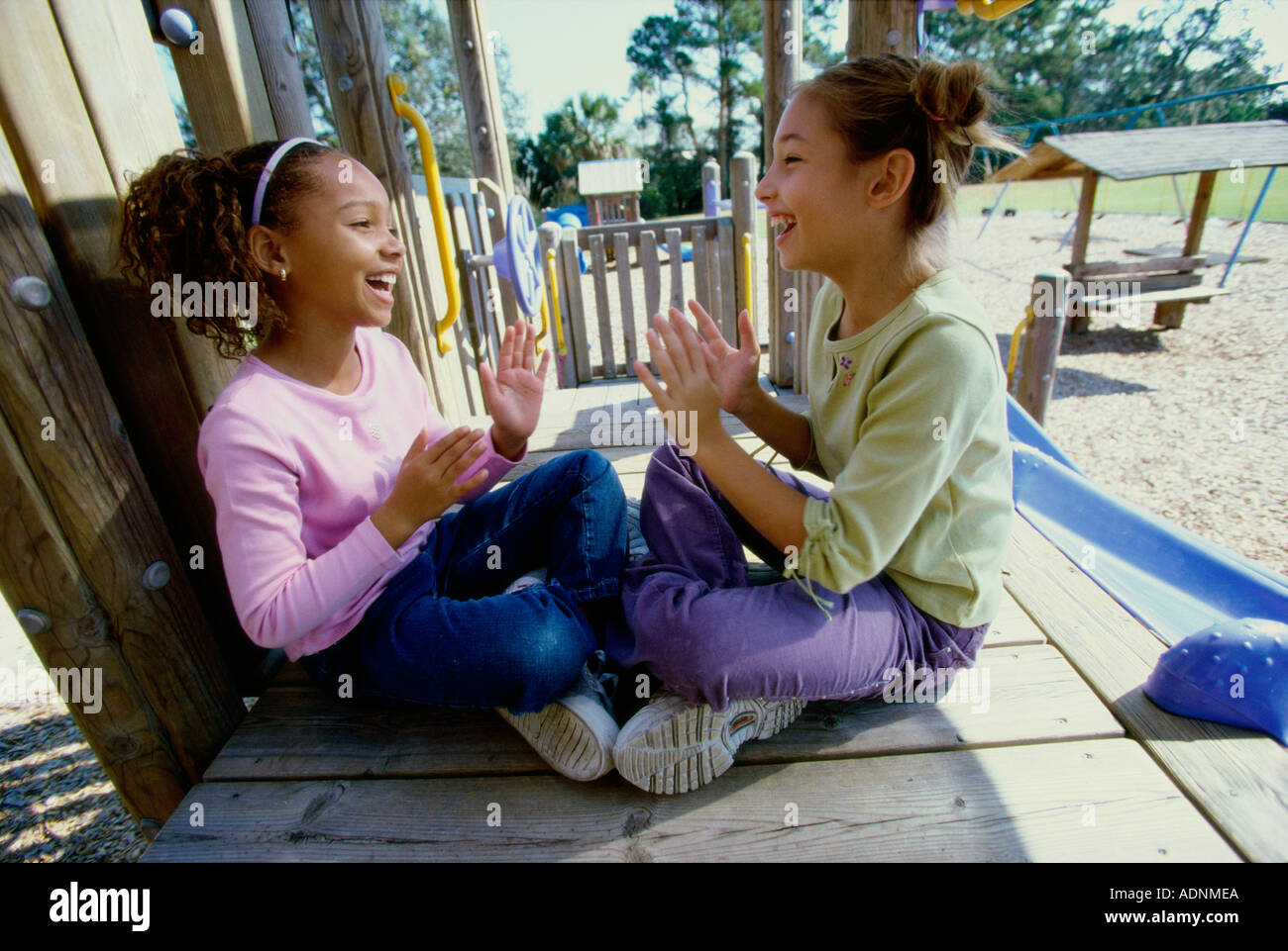 Side profile of two girls playing the clapping game Stock Photo - Alamy