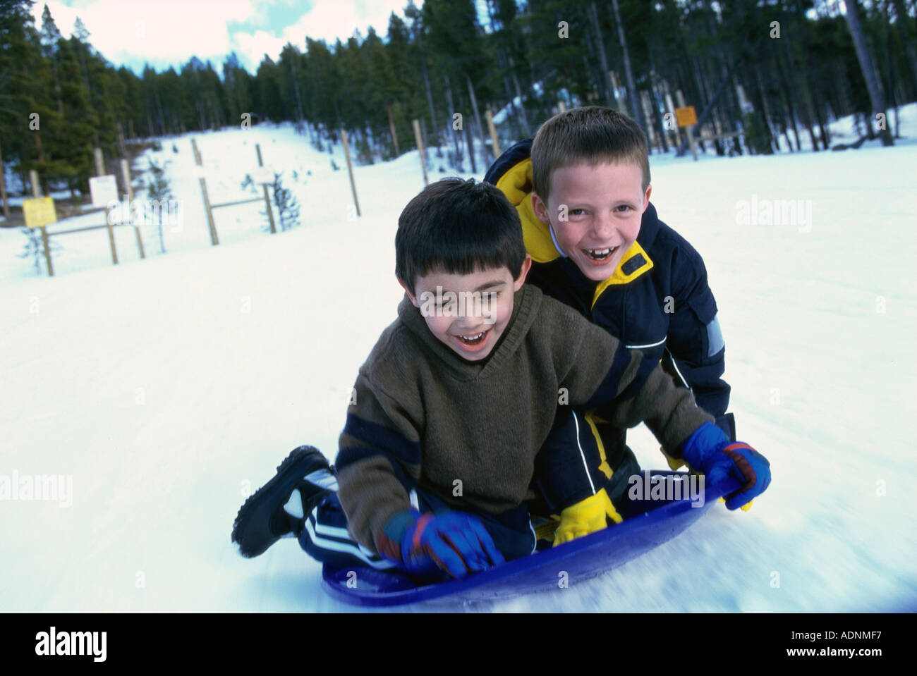Two boys riding on a sled Stock Photo - Alamy