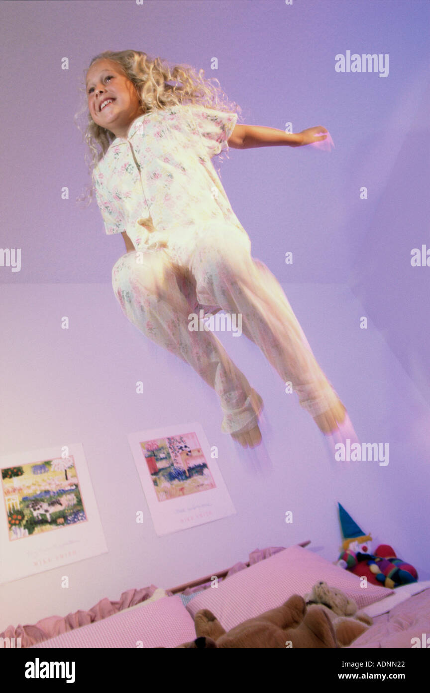 Girl jumping on a bed Stock Photo - Alamy