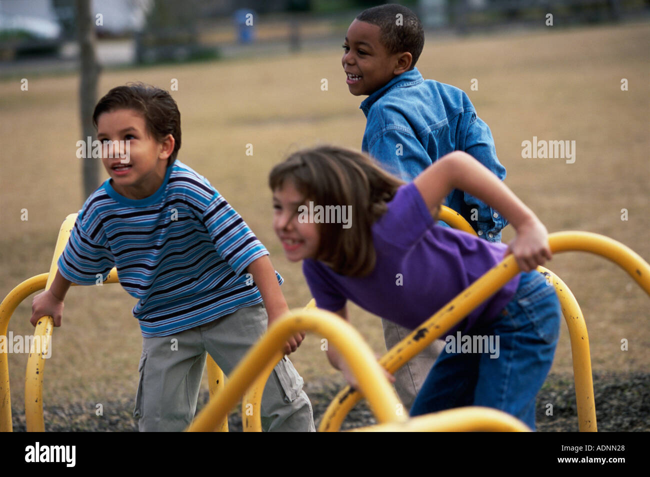 Two boys and a girl on a merry-go-round Stock Photo - Alamy