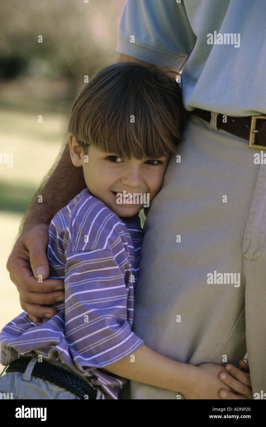 Side profile of a boy hugging his father's leg Stock Photo - Alamy