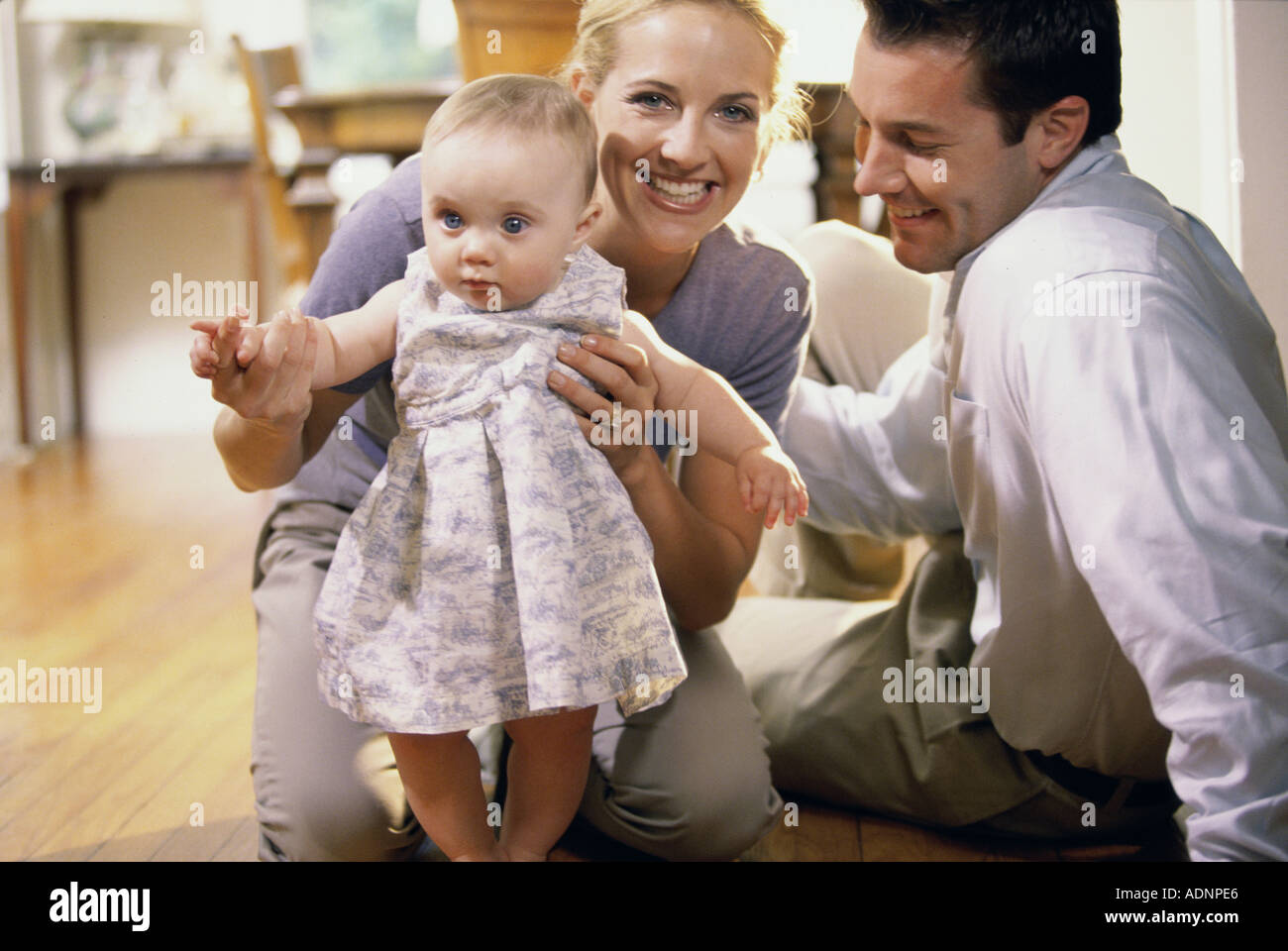 Parents helping their baby girl learn how to walk Stock Photo - Alamy