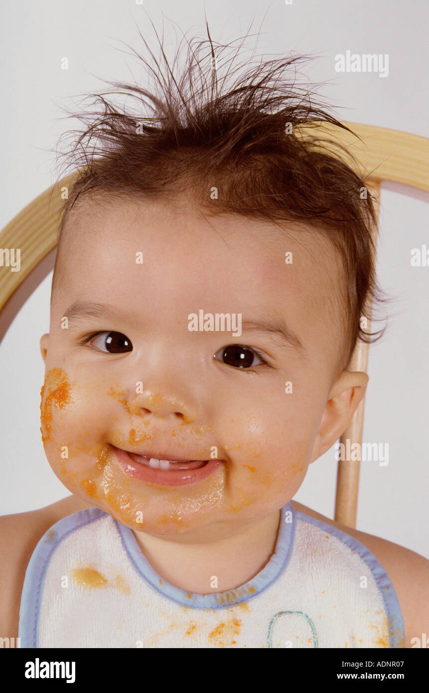 Portrait of a baby boy smiling with food on his face Stock Photo - Alamy