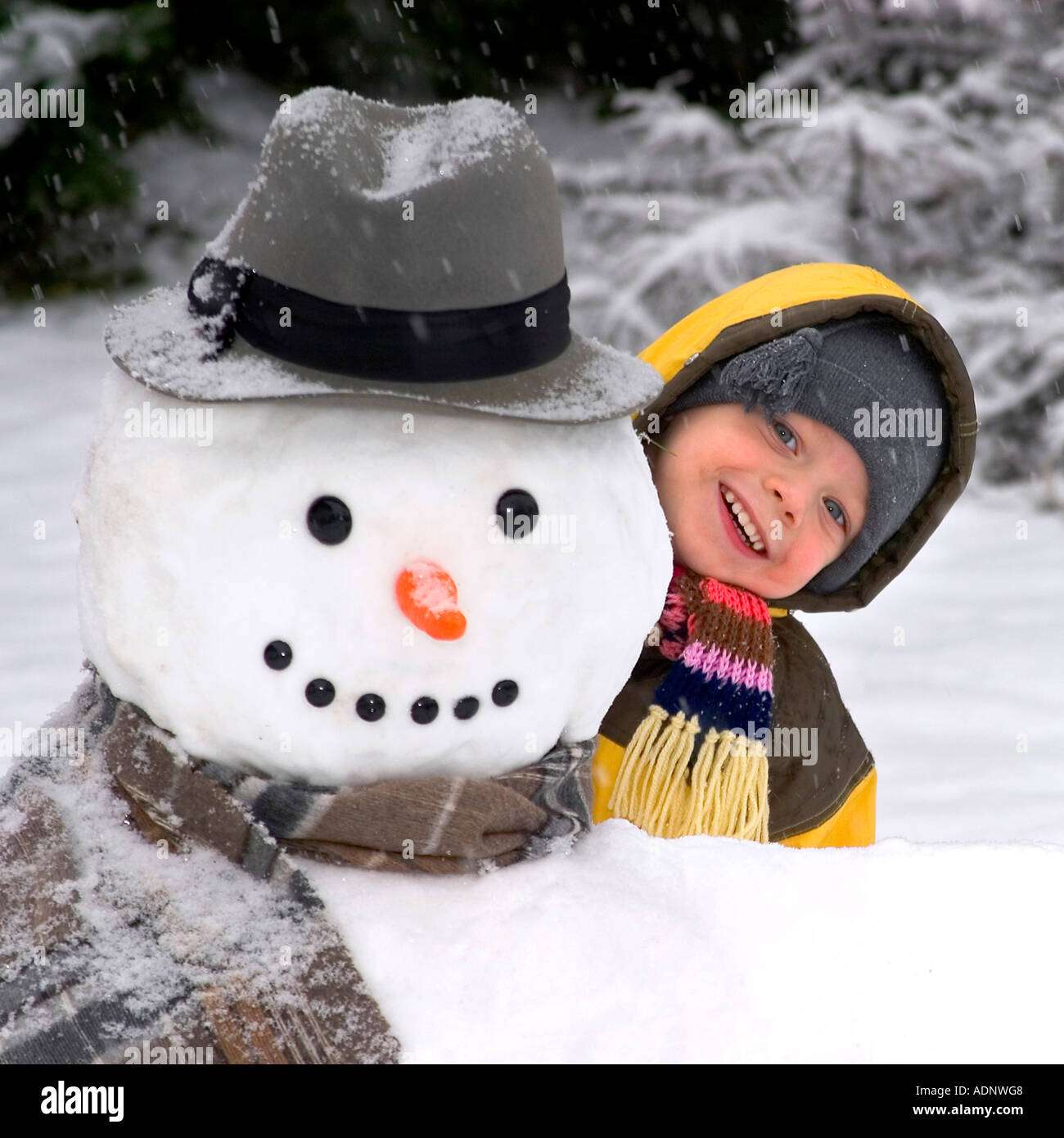 Little boy behind a snowman Stock Photo - Alamy