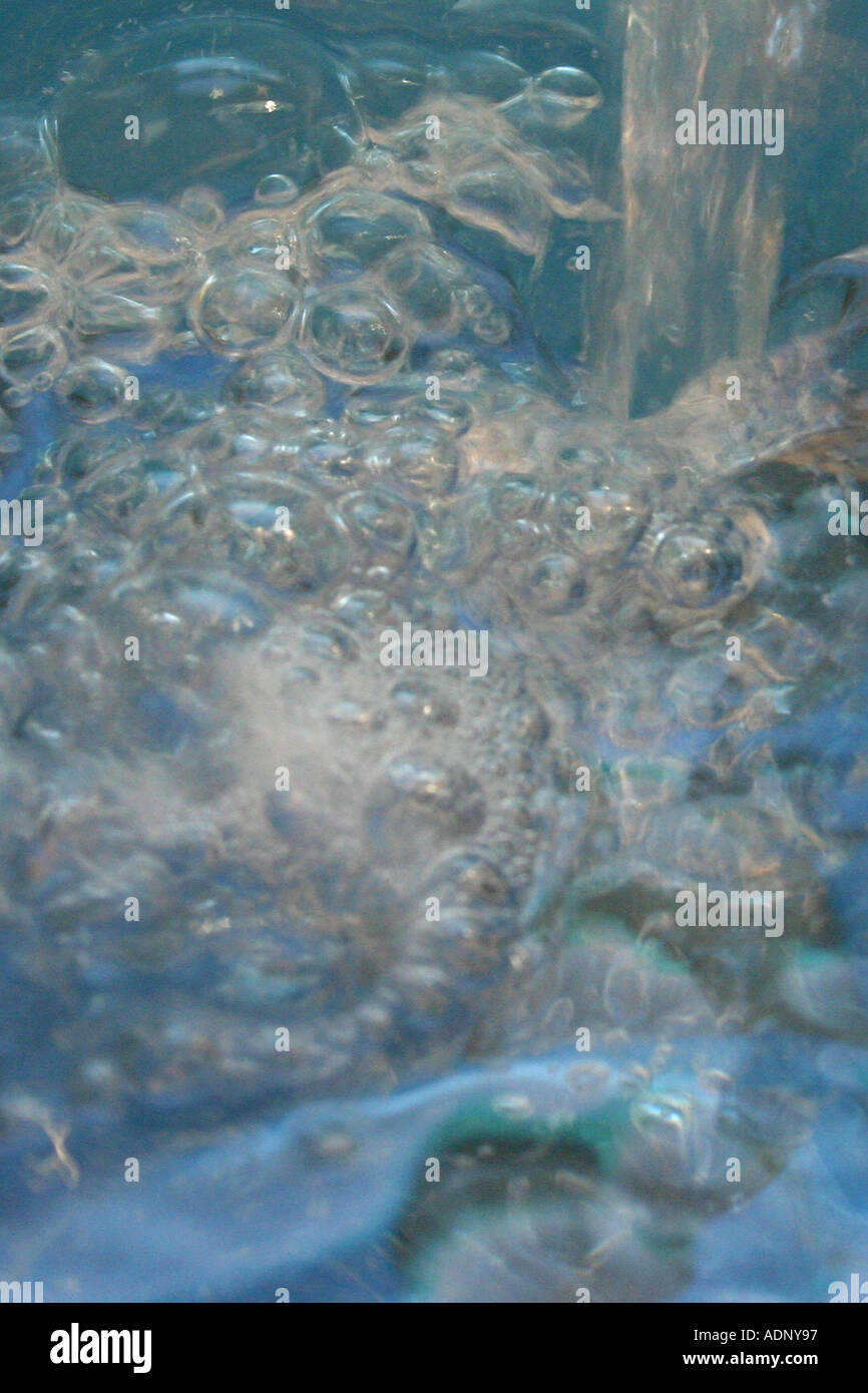 Water pouring into glass blue bubbles Stock Photo - Alamy