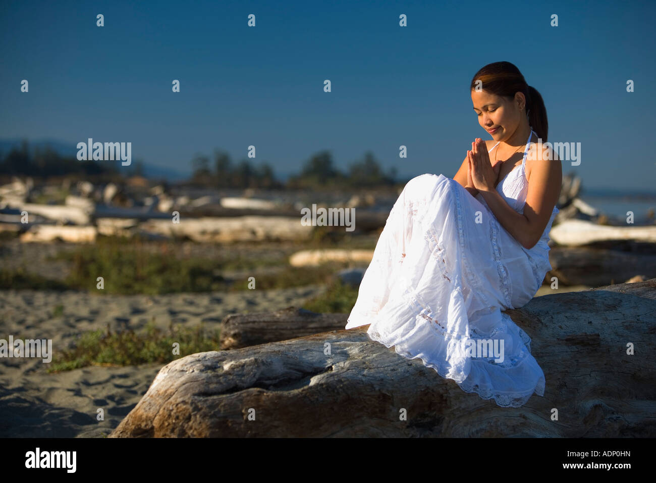 A young woman praying on the beach Stock Photo - Alamy