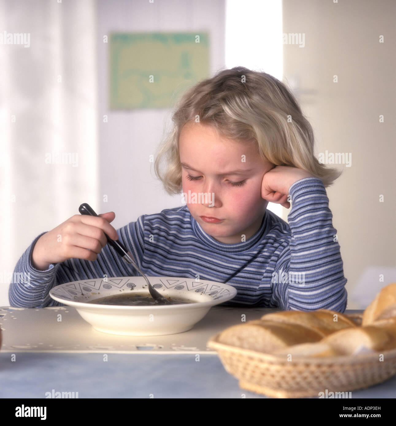 Little girl with a dish of soup and no appetite Stock Photo - Alamy