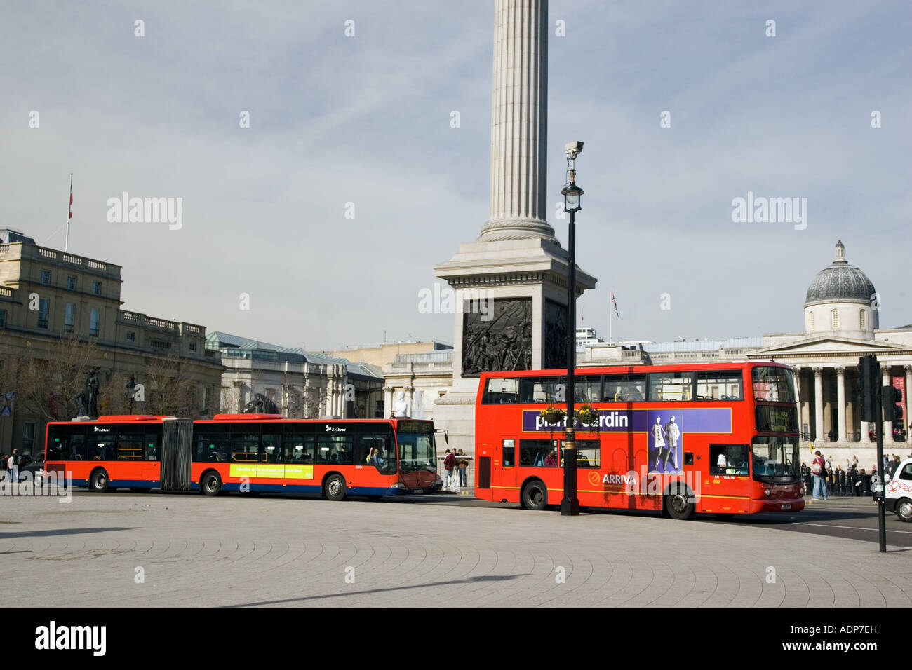 Public transport buses driving on bus routes in Trafalgar Square London ...