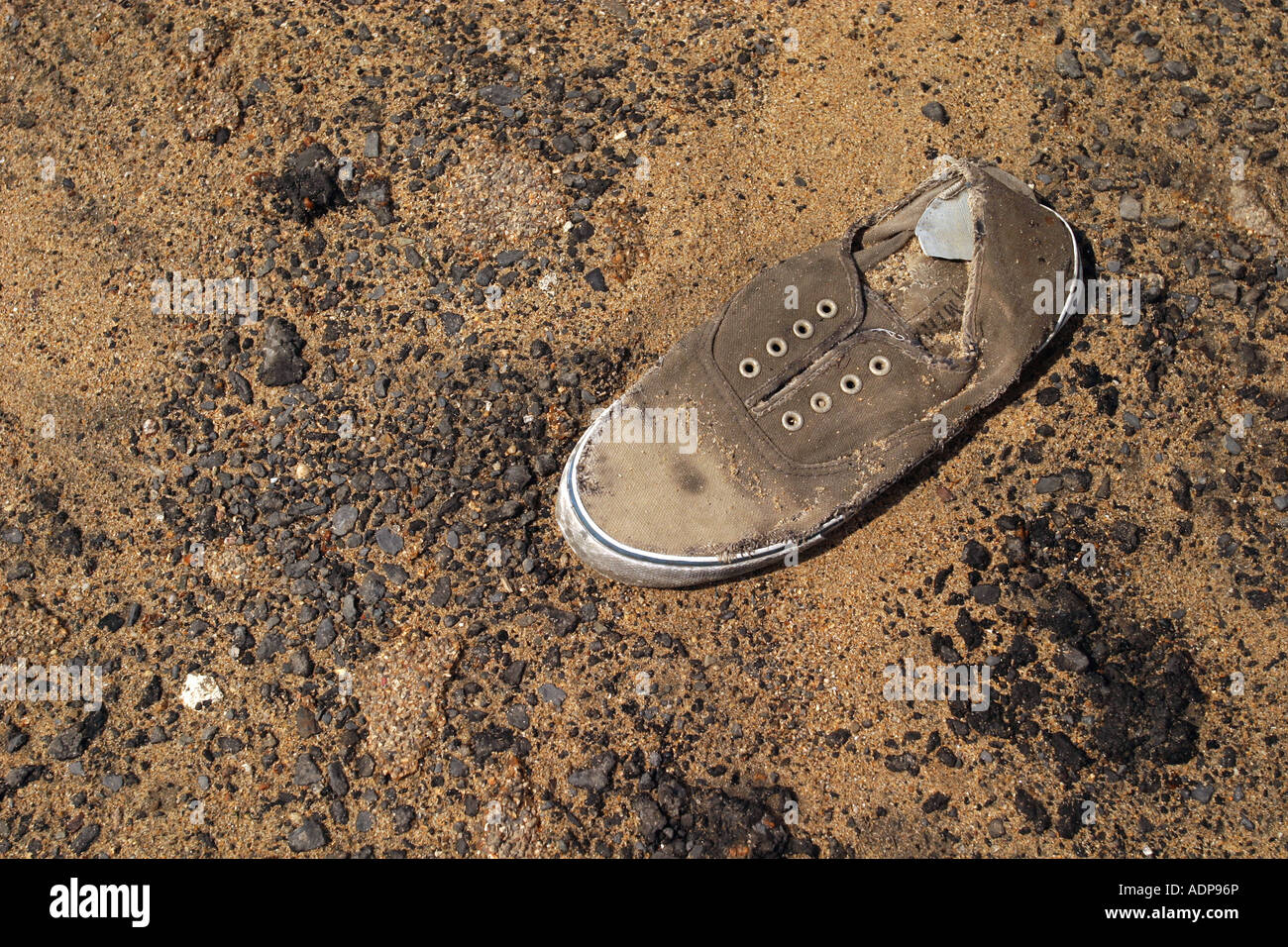 old plimsolls , plimsol flattened into road Stock Photo - Alamy
