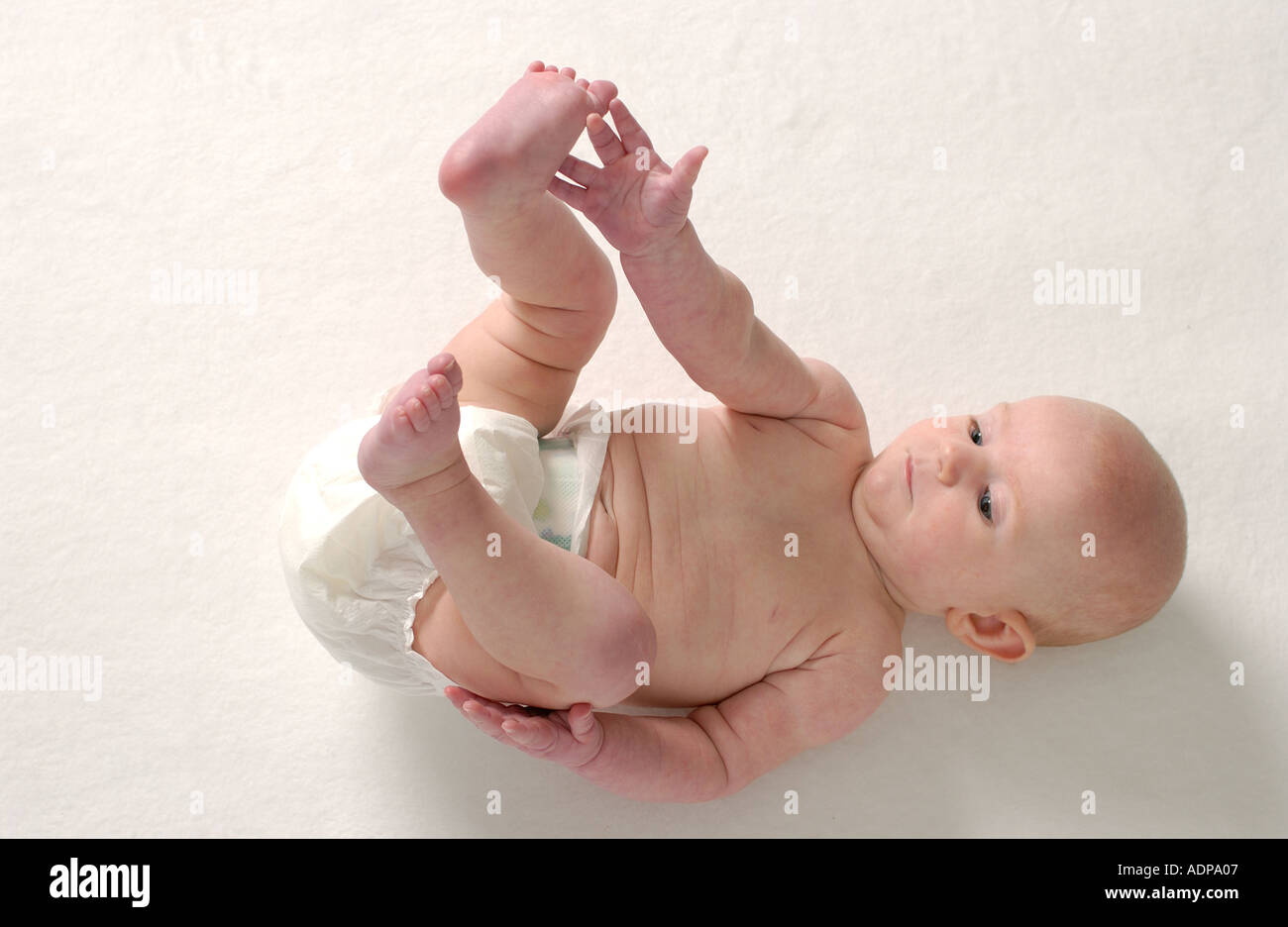 Baby grasping foot Stock Photo - Alamy