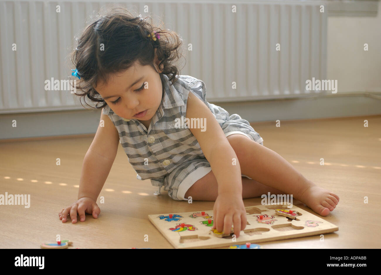 Little girl is playing with a puzzle Stock Photo - Alamy