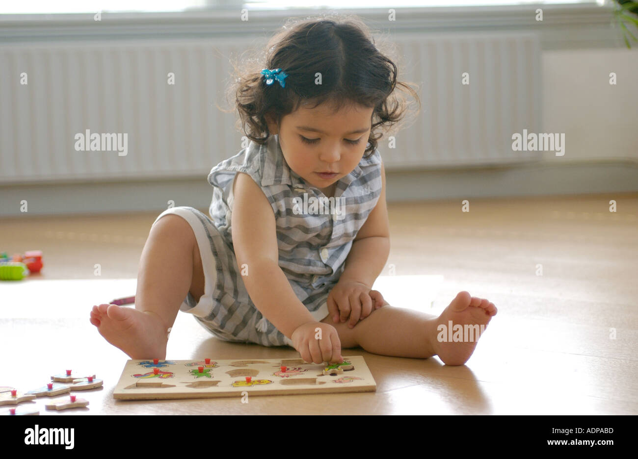 Little girl is playing with a puzzle Stock Photo - Alamy