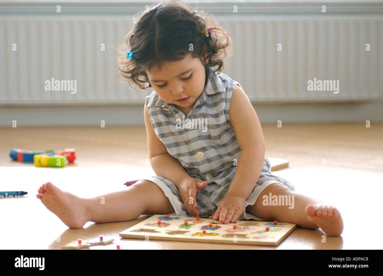 Little girl is playing with a puzzle Stock Photo - Alamy